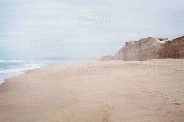 Peaceful beach scene with cliffs - Stock Photo - Dissolve