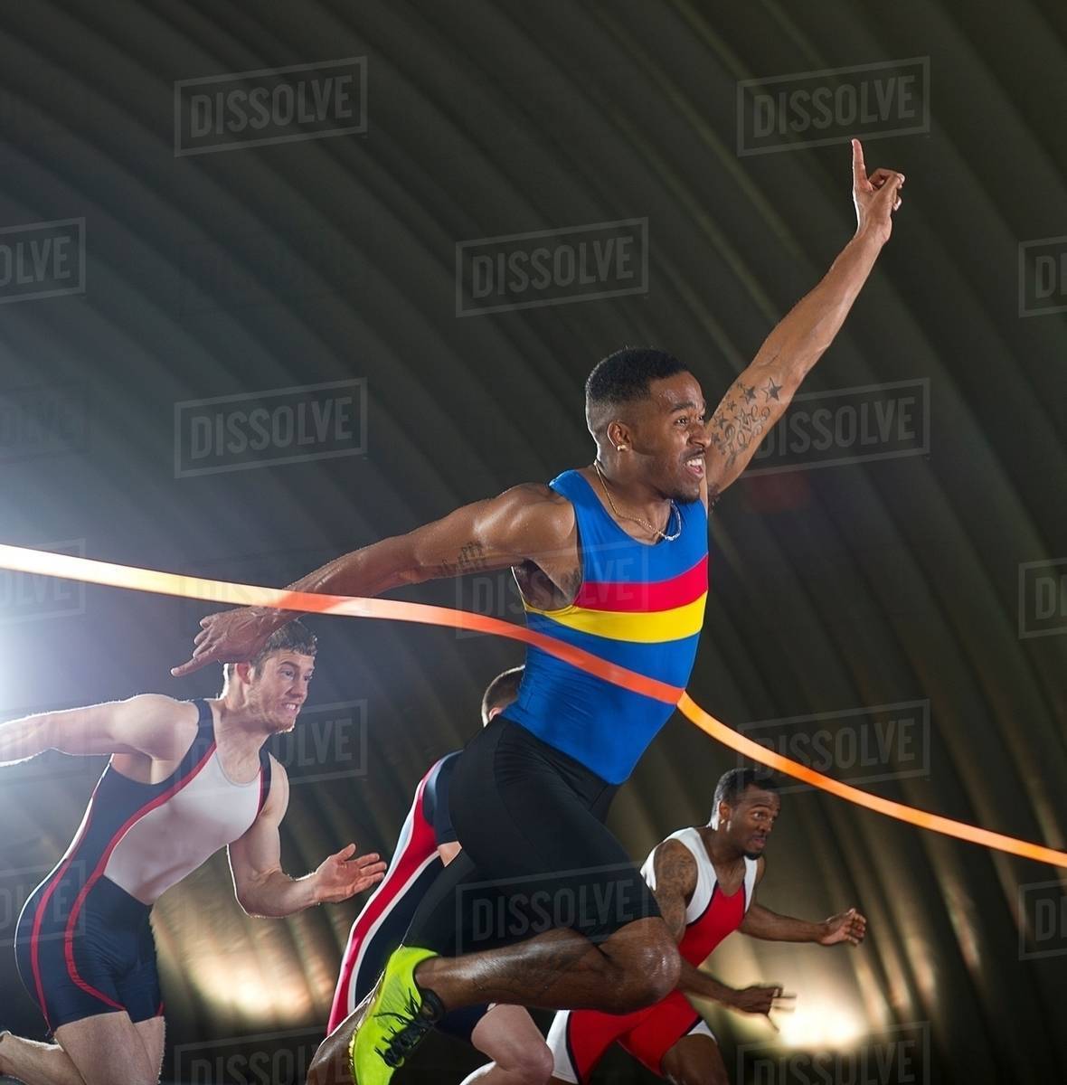 Athlete reaching finish line in race - Stock Photo - Dissolve