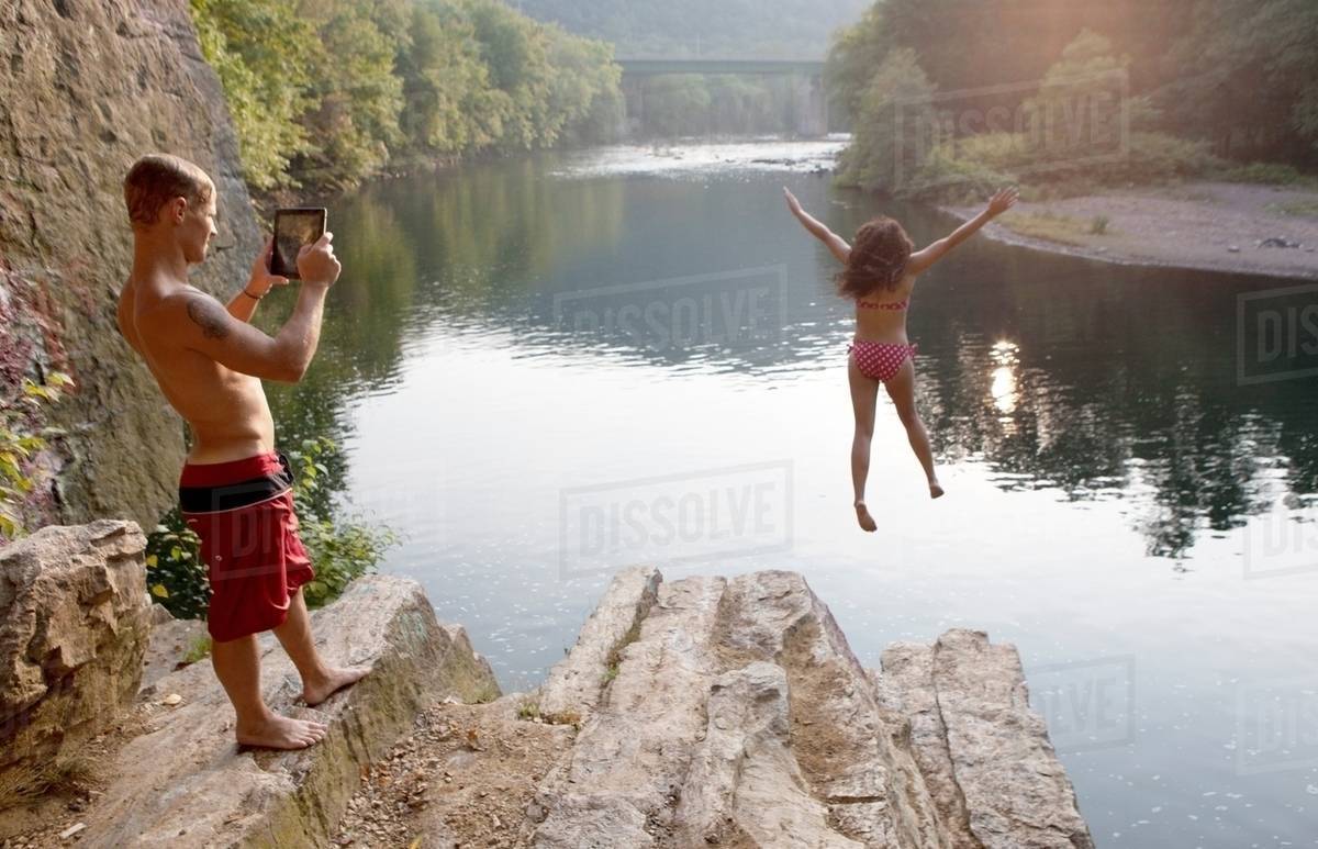 Young couple photographing jump from rock ledge, Hamburg, Pennsylvania ...