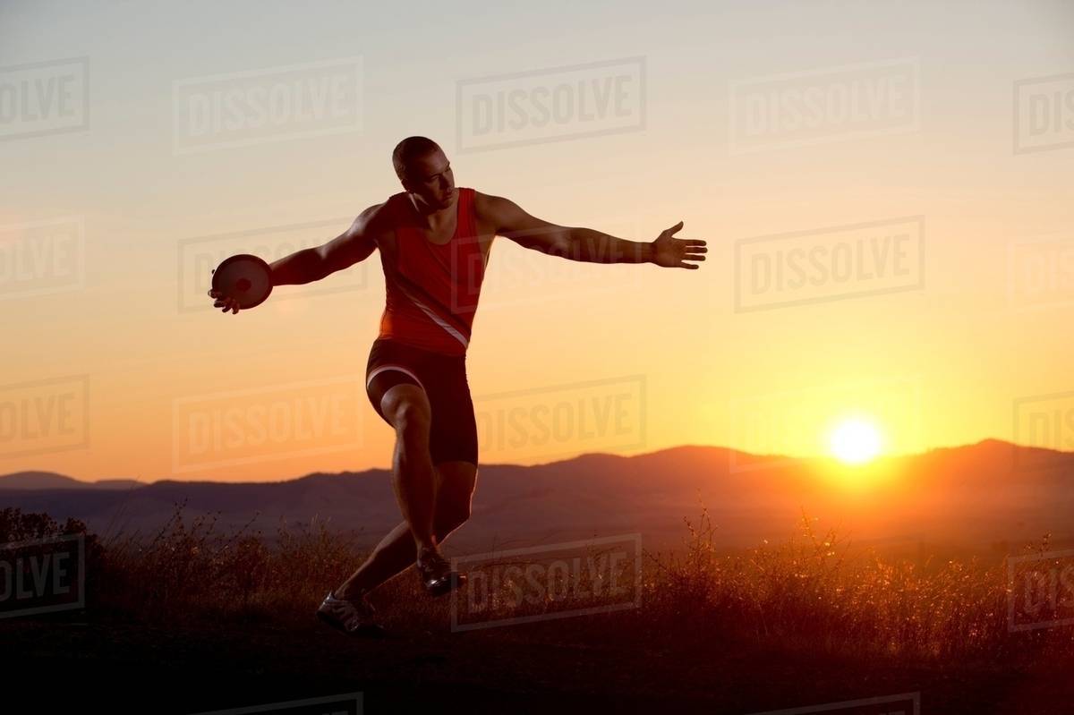Young man preparing to throwing discus at sunset - Royalty-free Stock ...