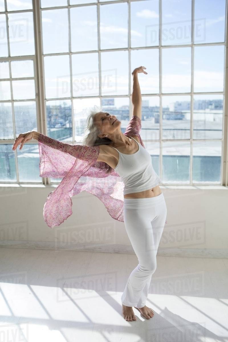 Senior woman dancing in sunlit apartment - Royalty-free Stock Photo ...