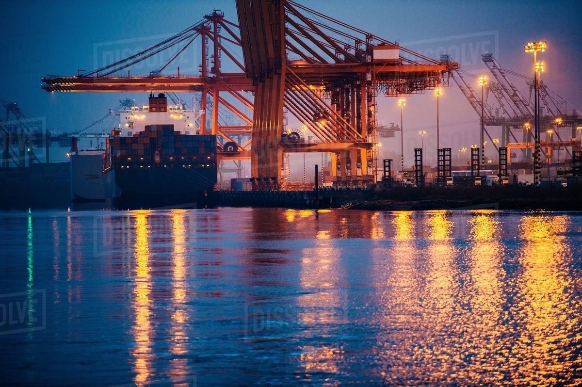 View of cargo ship and gantry cranes in harbor at night, Tacoma ...