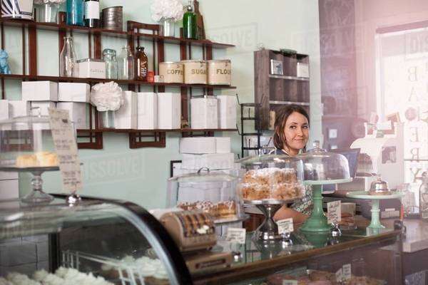 Bakery owner standing behind counter of vegan, allergy-friendly bakery ...