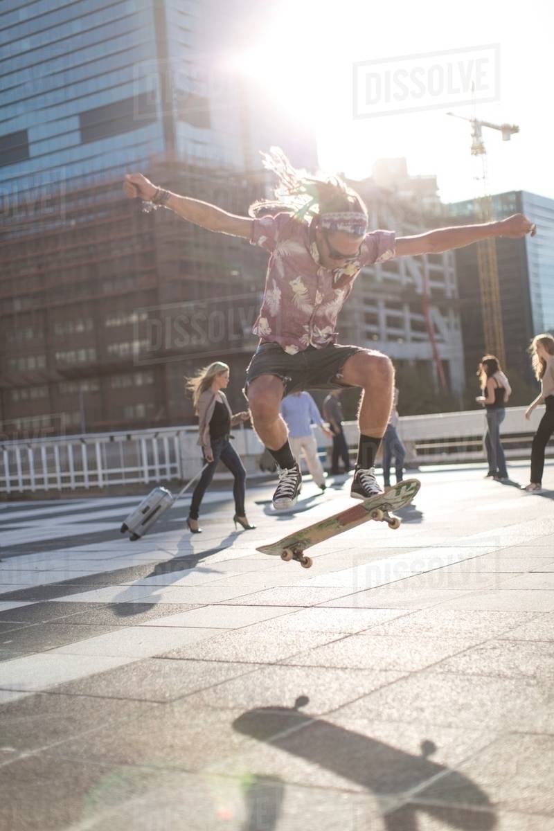 Skateboarder performing trick in urban area - Stock Photo - Dissolve