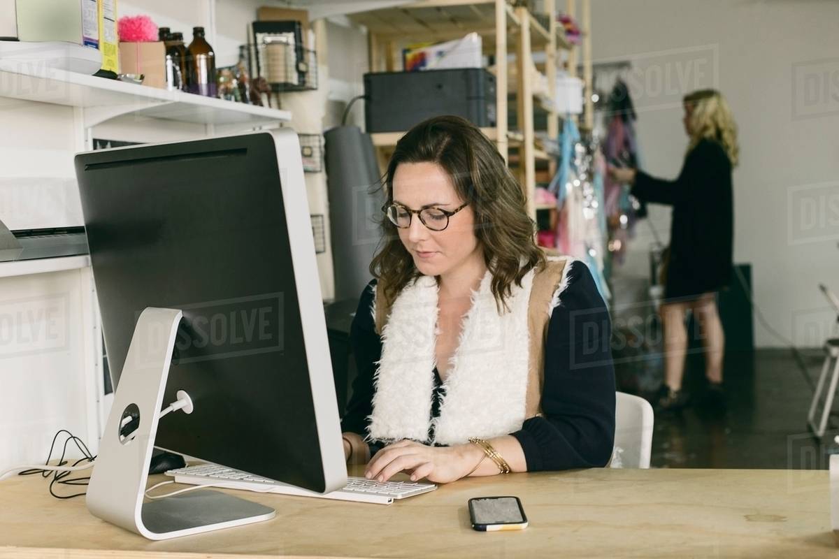 Female office worker at desk in design studio - Royalty-free Stock ...