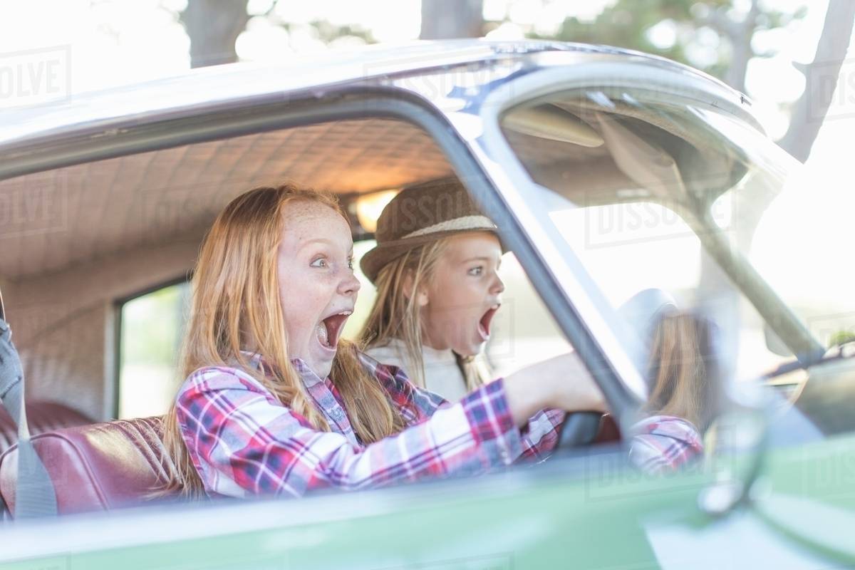 Two young girls driving car, looking scared - Royalty-free Stock Photo ...
