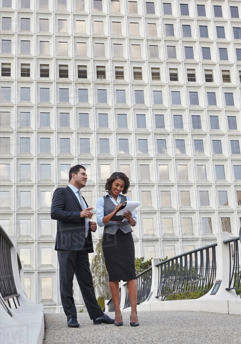 Business people standing talking holding paperwork - Royalty-free Stock ...