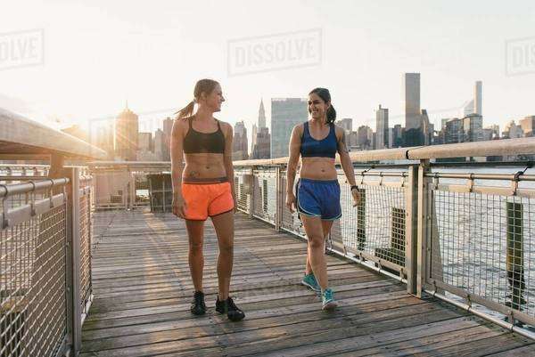 Two friends exercising together, running outdoors by river - Stock ...