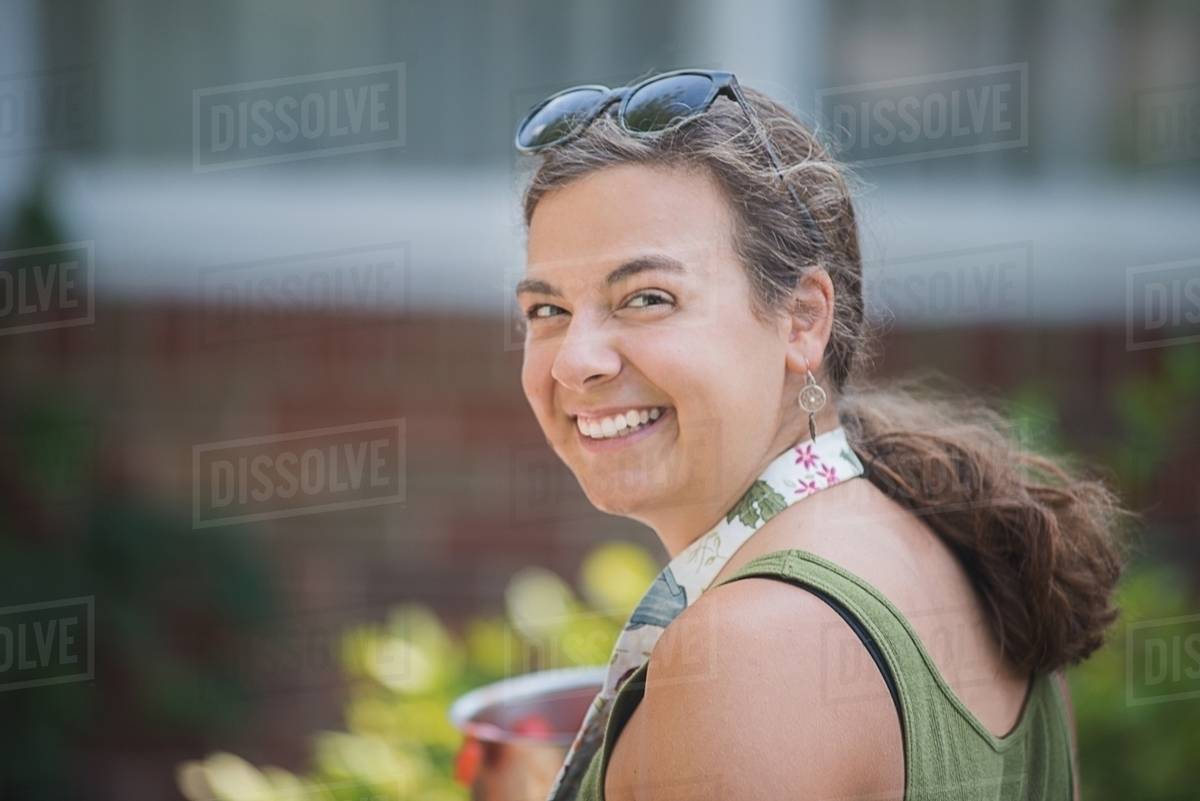 Portrait of woman looking over shoulder at camera smiling - Royalty ...