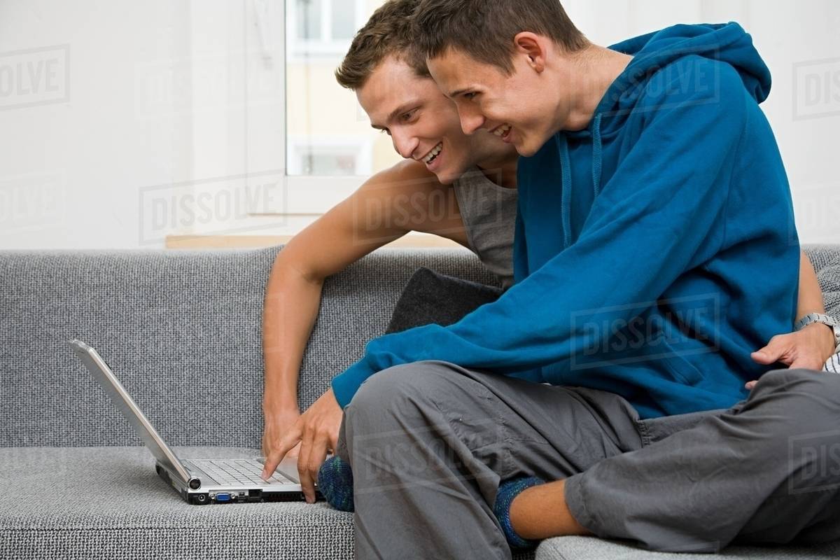 A gay couple using a laptop - Stock Photo - Dissolve