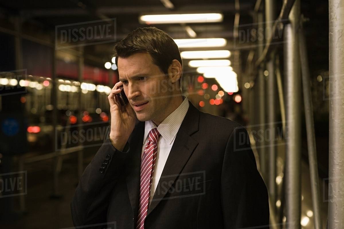 Businessman using a cellular telephone - Stock Photo - Dissolve