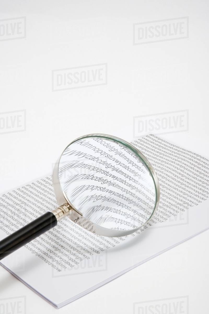 Magnifying glass and a stack of paper - Royalty-free Stock Photo | Dissolve
