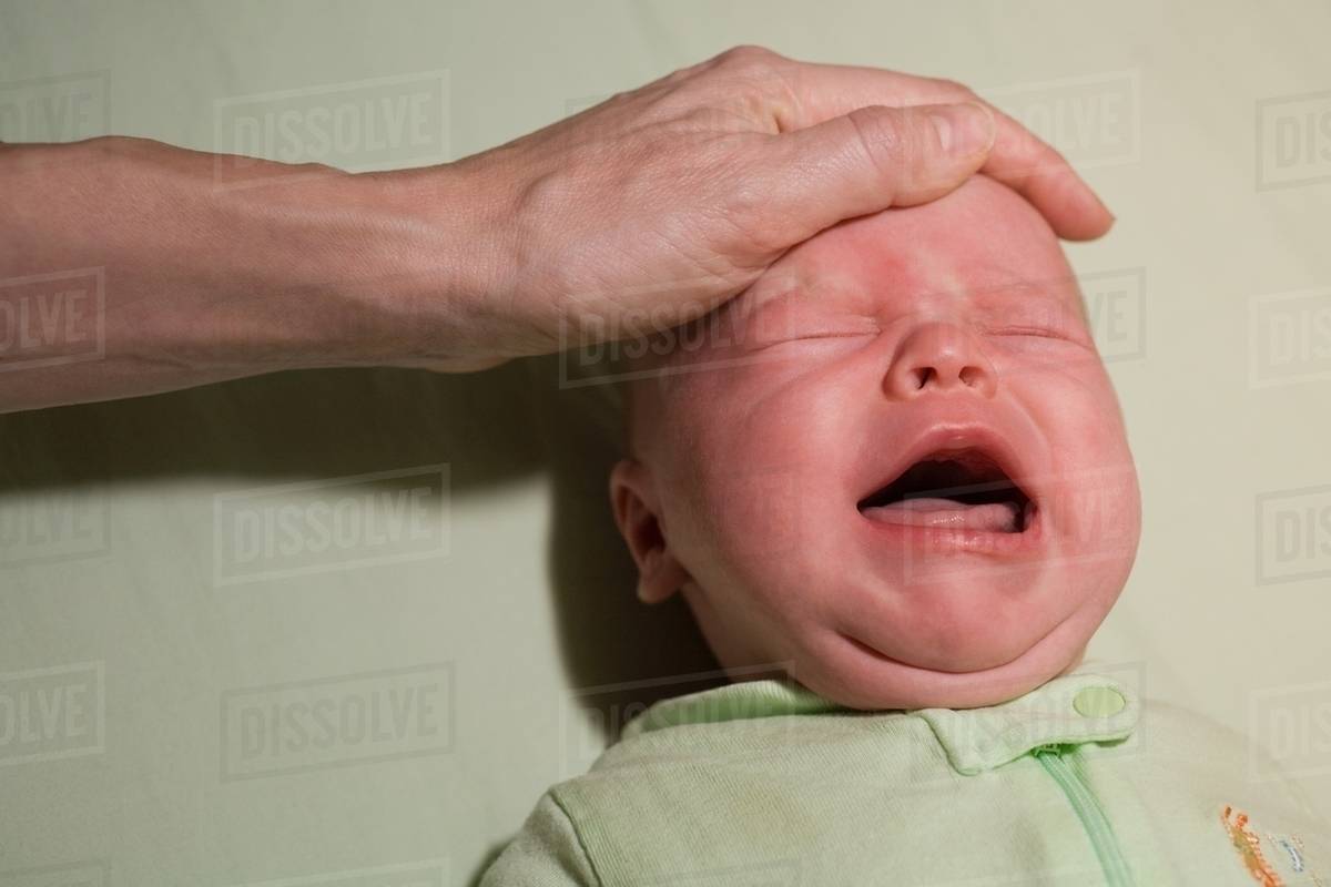 Person comforting crying baby - Stock Photo - Dissolve