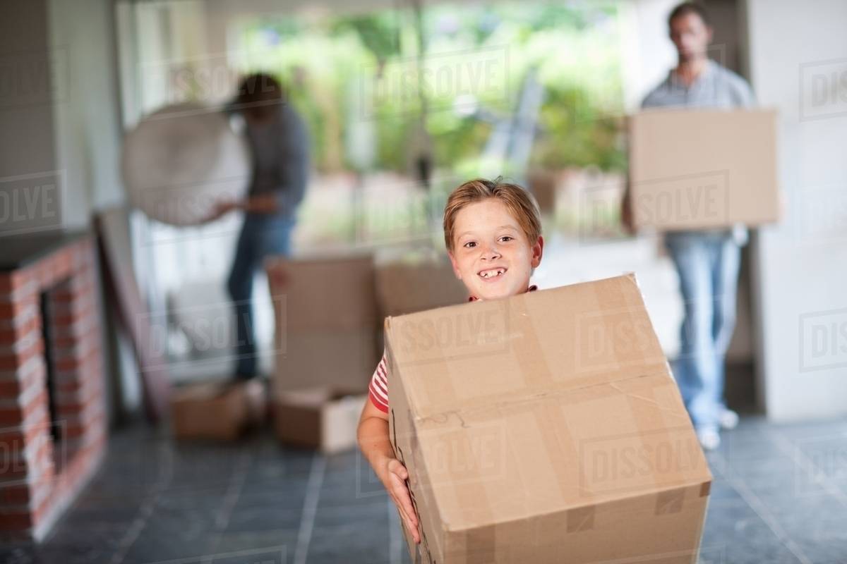 Boy moving house carrying cardboard box - Royalty-free Stock Photo ...