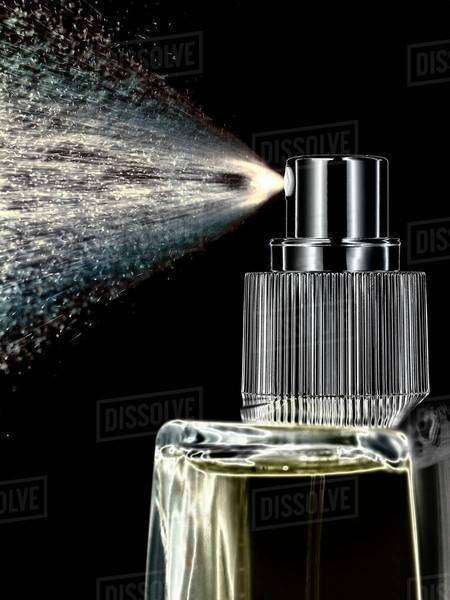 Close up of perfume spraying from bottle - Stock Photo - Dissolve