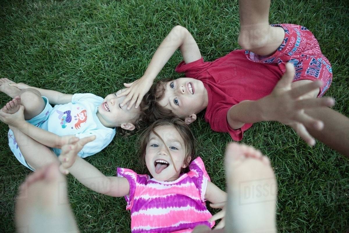 Children playing in grassy field - Royalty-free Stock Photo | Dissolve