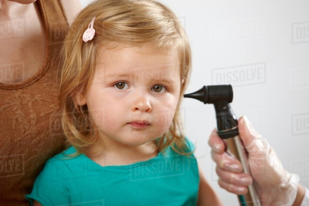 Little girl having her ear checked - Royalty-free Stock Photo | Dissolve