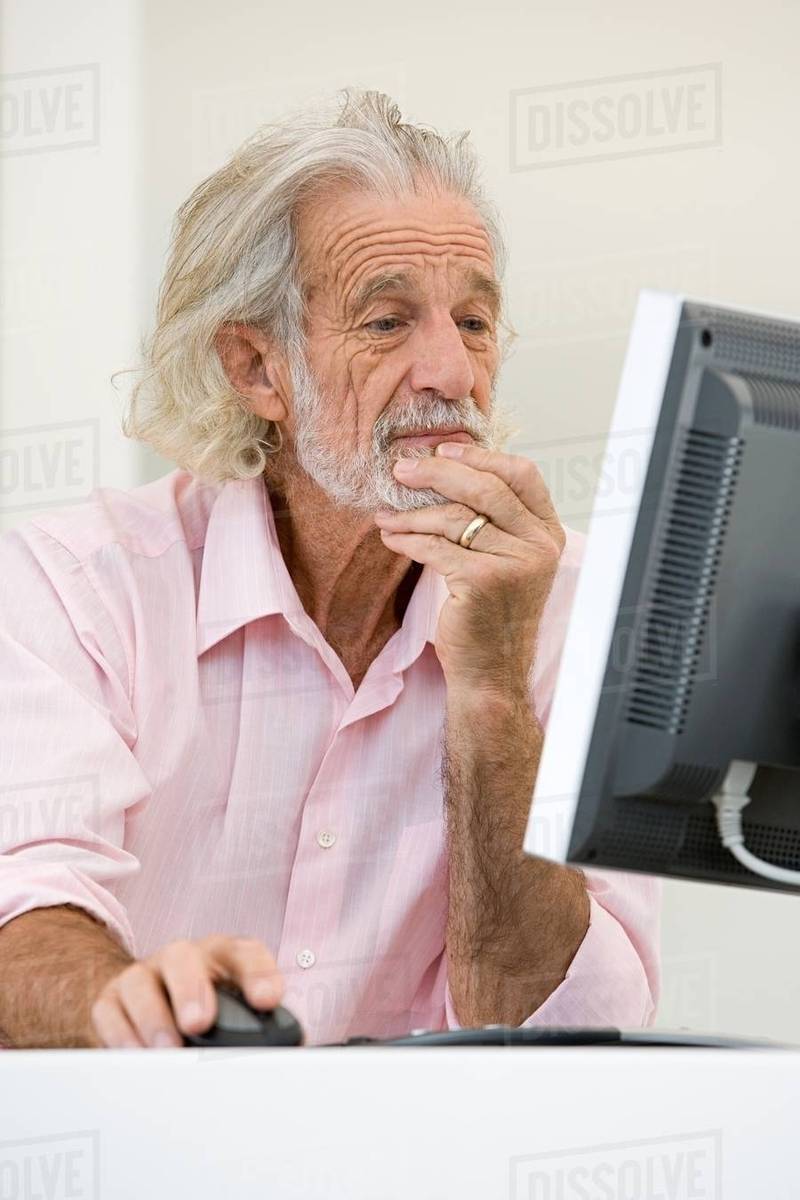 Senior man using computer - Stock Photo - Dissolve