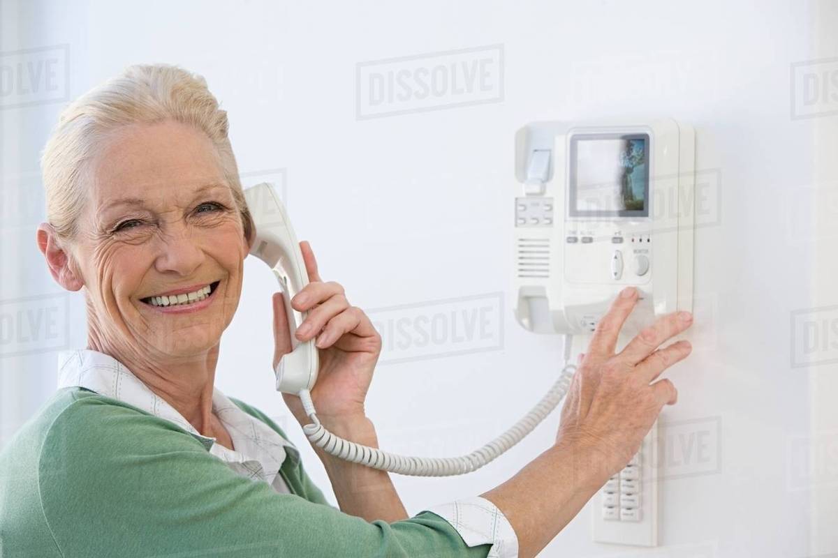 Woman using intercom - Royalty-free Stock Photo | Dissolve