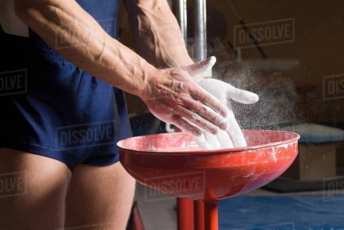 Gymnast putting chalk on his hands - Royalty-free Stock Photo | Dissolve