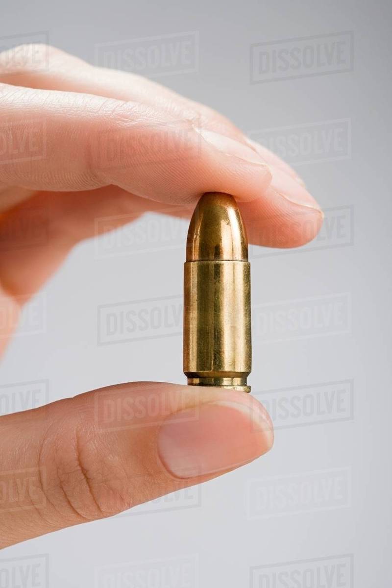 Person holding a bullet - Royalty-free Stock Photo | Dissolve