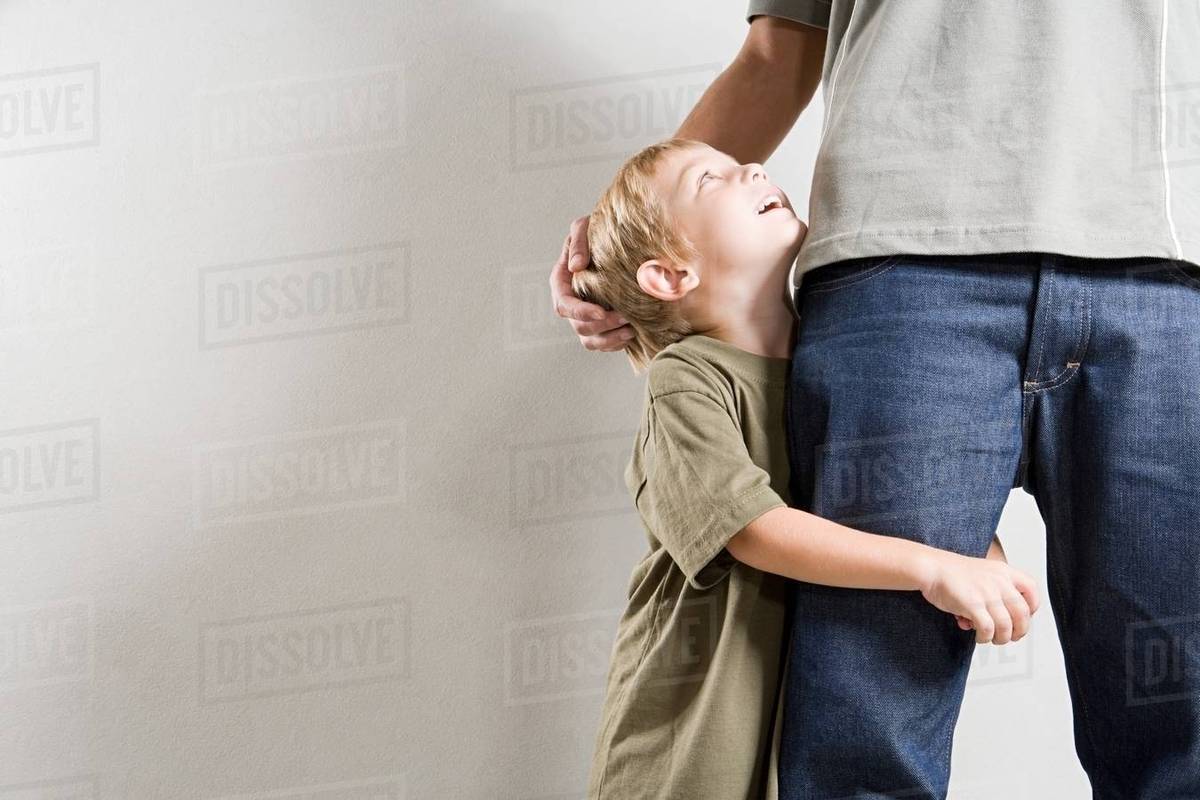 A boy hugging his fathers leg - Royalty-free Stock Photo | Dissolve