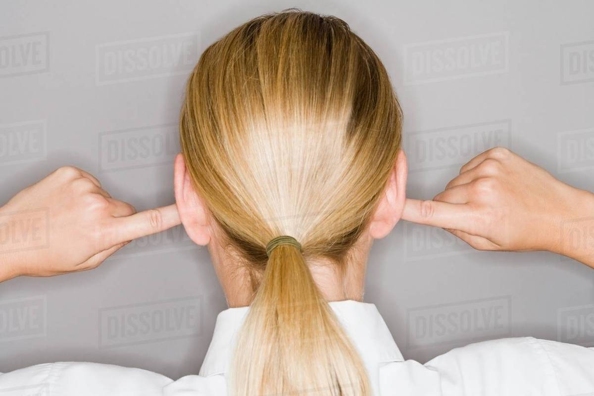 A woman with her fingers in her ear - Royalty-free Stock Photo | Dissolve