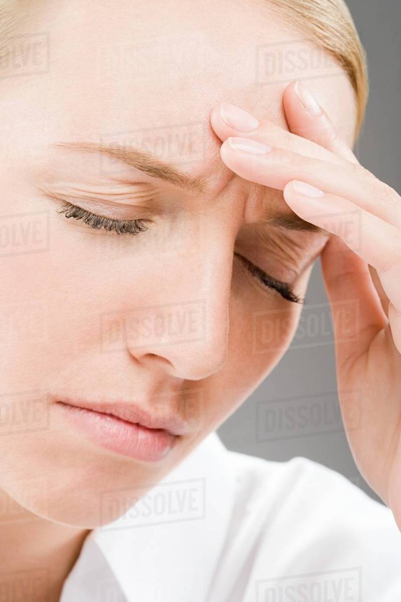 A woman touching her head - Royalty-free Stock Photo | Dissolve