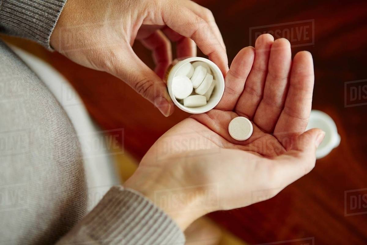 Young woman taking medication from tub, close-up - Royalty-free Stock ...