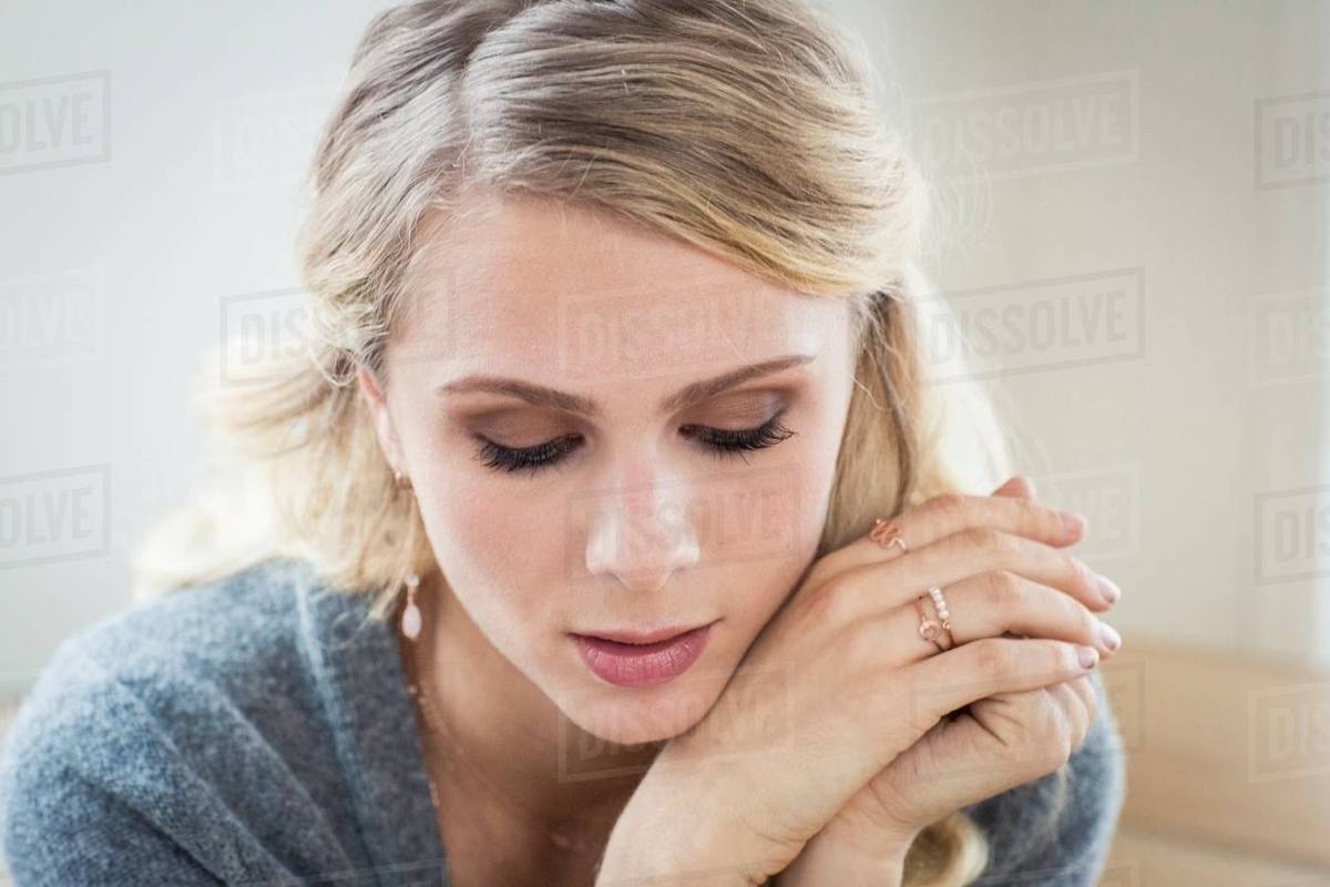 Portrait of young woman hand on cheek looking down - Royalty-free Stock ...