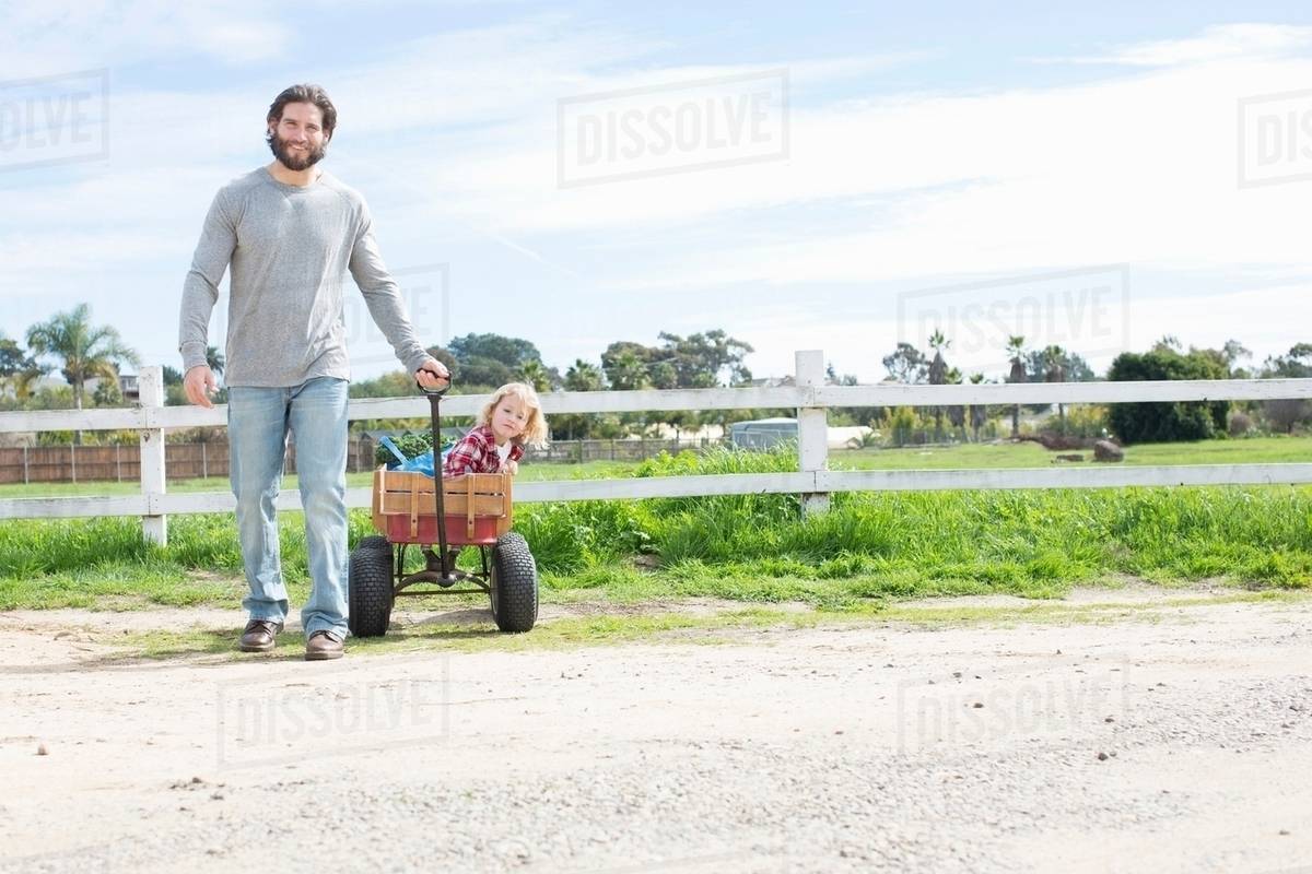 Father pulling son in wagon - Royalty-free Stock Photo | Dissolve
