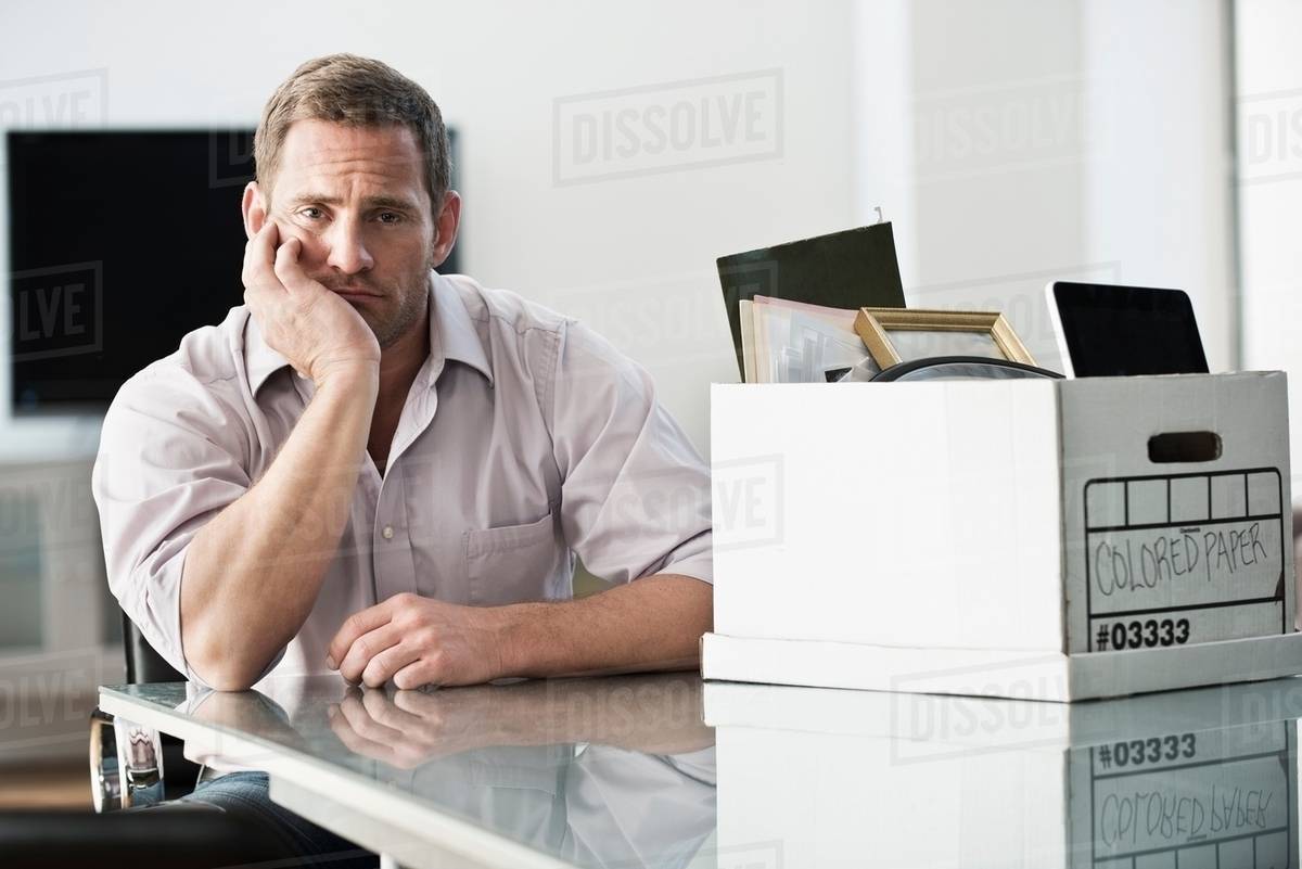 Businessman packing up box in office - Royalty-free Stock Photo | Dissolve