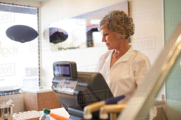 Cashier wearing uniform in store - Royalty-free Stock Photo | Dissolve