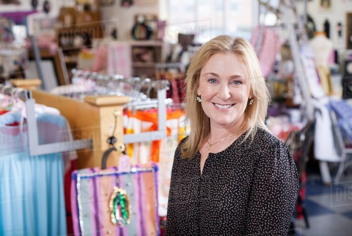 Woman smiling in thrift store - Stock Photo - Dissolve