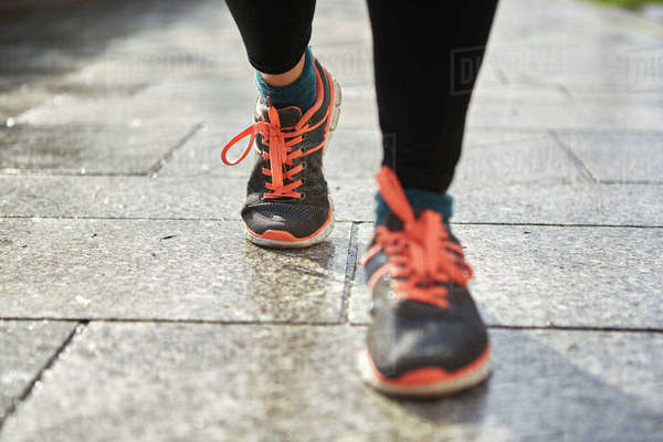 Legs of woman wearing running shoes on pavement - Stock Photo - Dissolve
