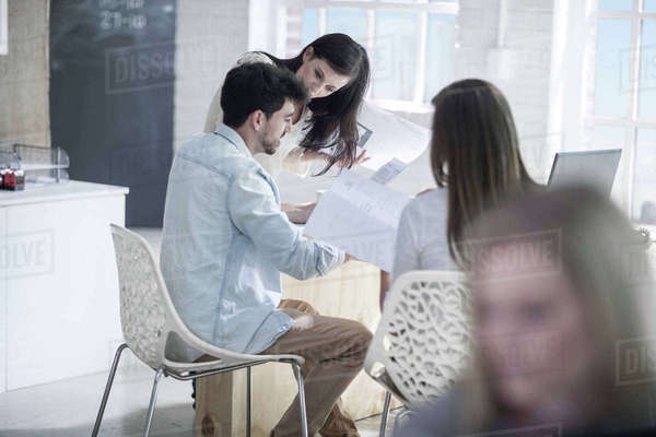 Design team meeting discussing blueprints in design studio - Royalty ...