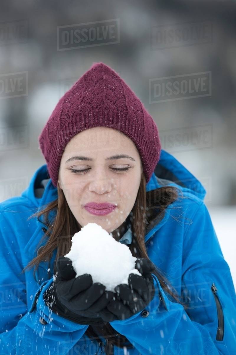Young woman holding snowball, close up - Stock Photo - Dissolve