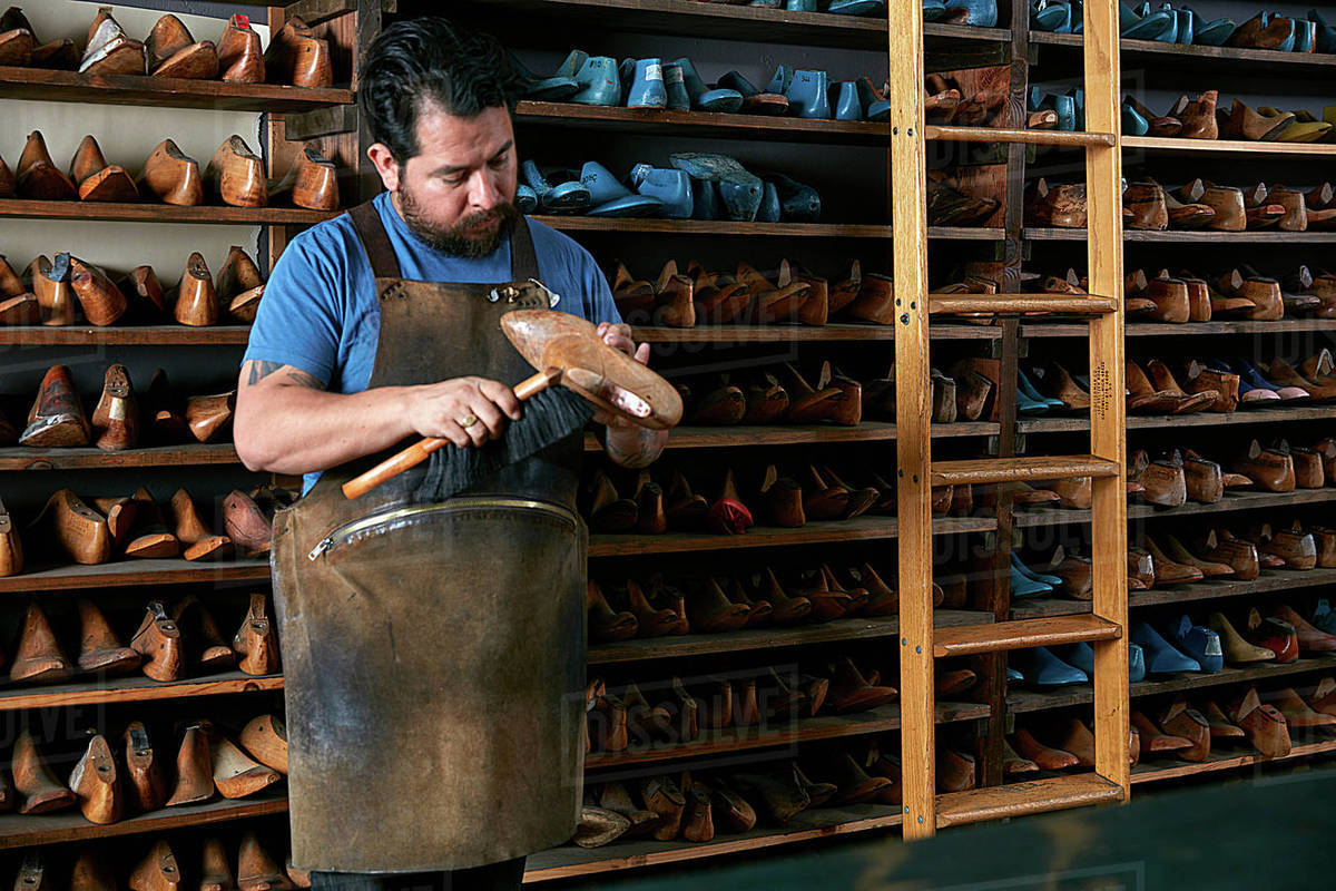 Male cobbler in traditional shoe shop adjusting shoe last - Royalty ...