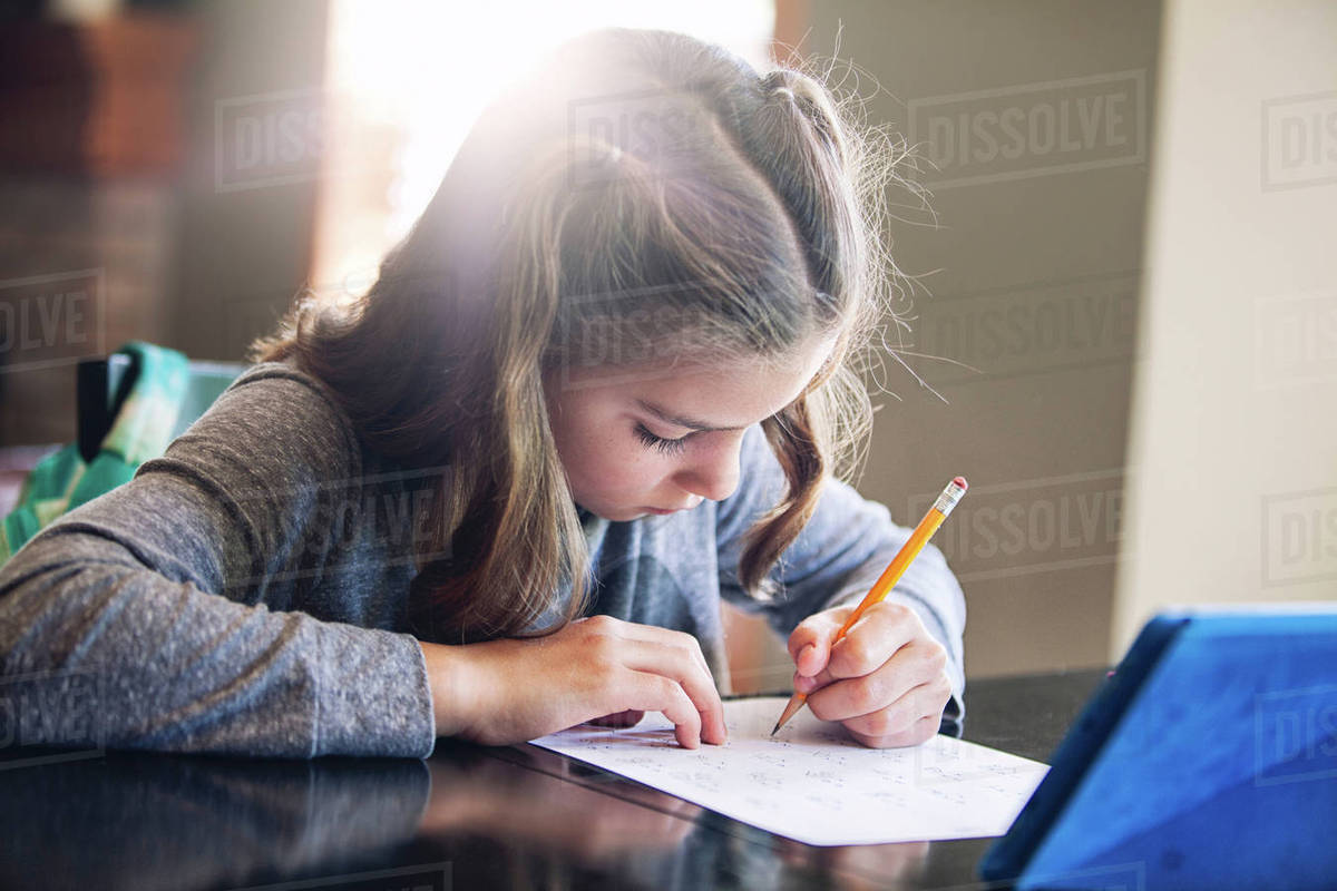 Girl at desk writing - Royalty-free Stock Photo | Dissolve