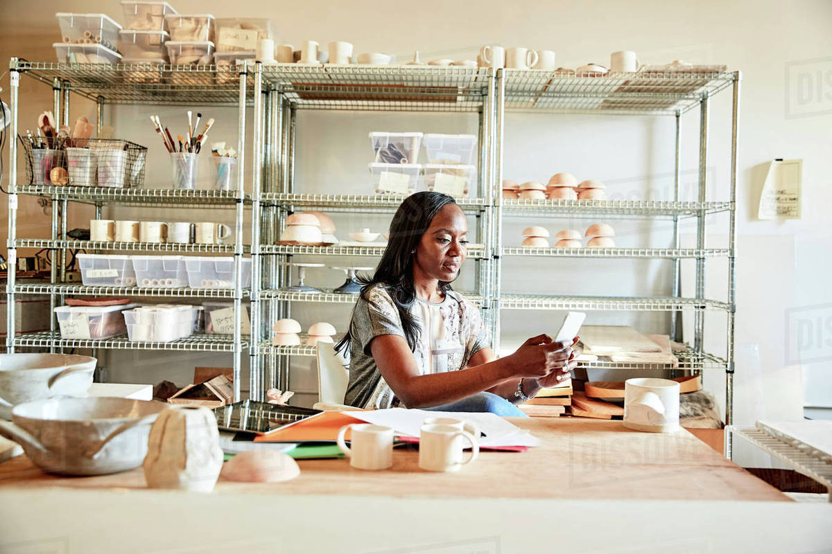Potter in workshop photographing pottery with smartphone - Royalty-free ...