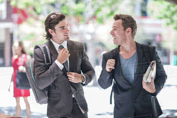 Two businessmen walking and talking in city - Stock Photo - Dissolve