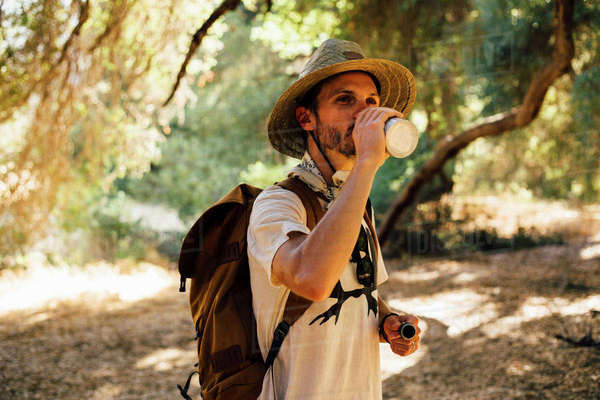 Hiker drinking from water bottle, Malibu Canyon, California, USA ...