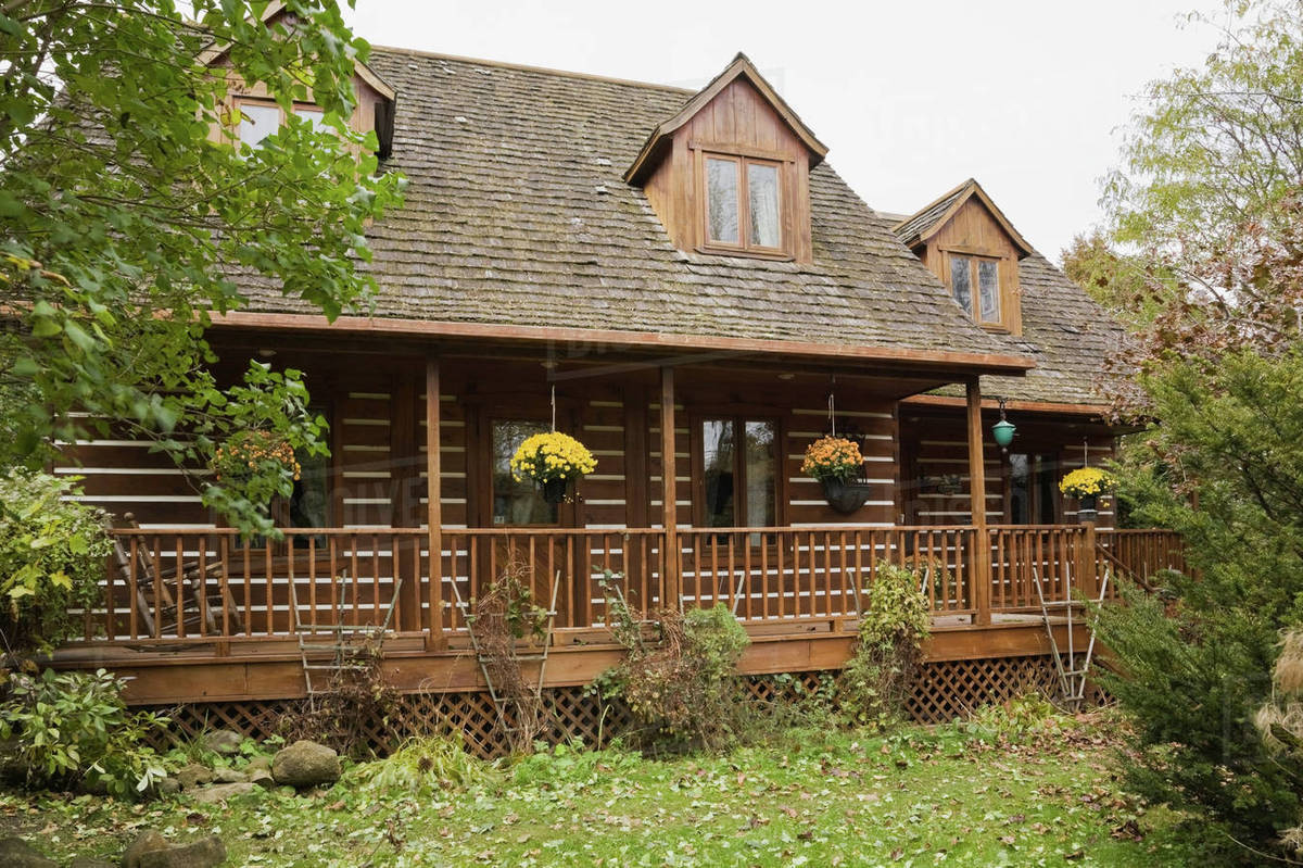 Rustic Canadian cottage style log home facade and landscaped front lawn ...