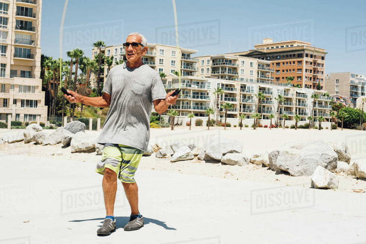 Senior man, skipping on beach, Long Beach, California, USA - Royalty ...