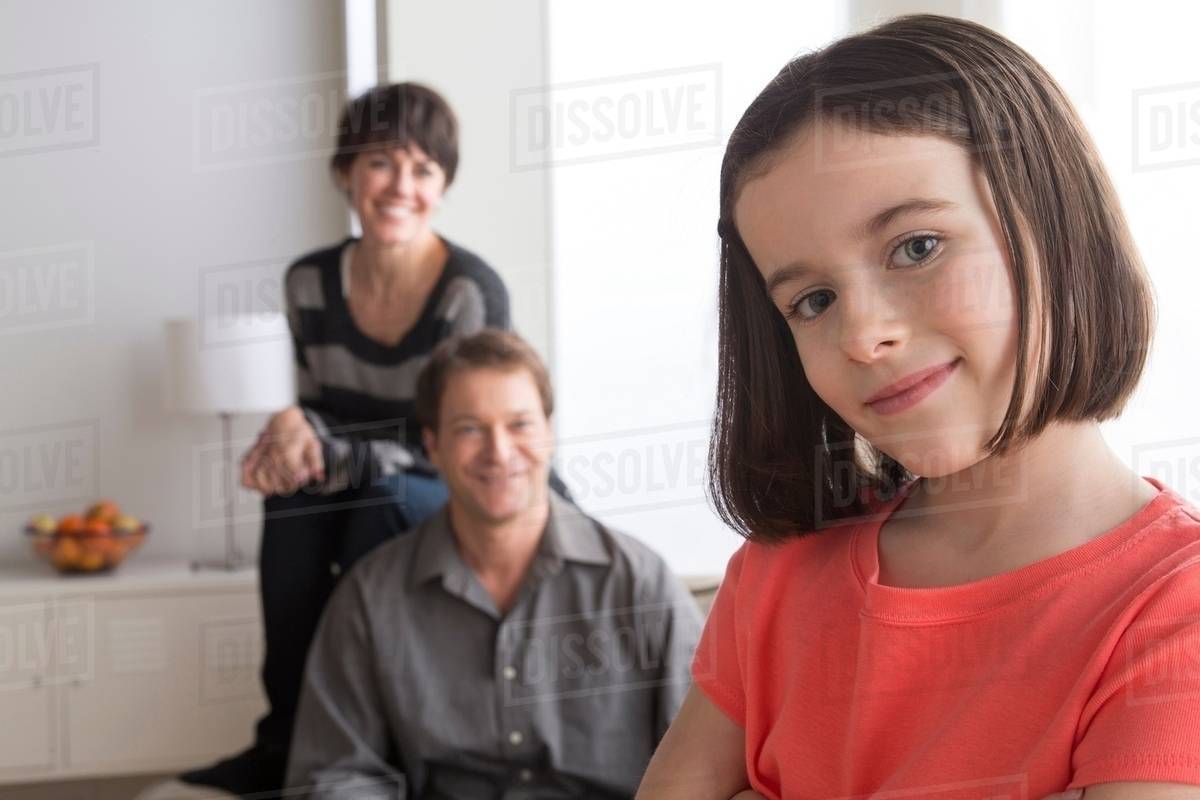 Portrait of girl with parents in background - Stock Photo - Dissolve