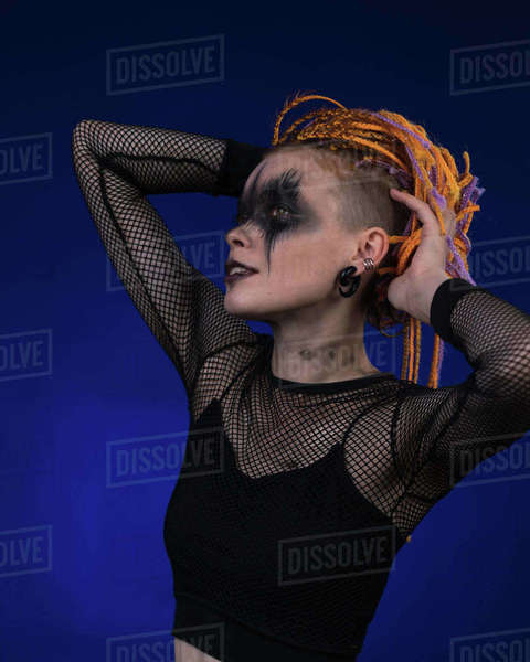 Female with orange color braids hairdo and horror black stage makeup ...