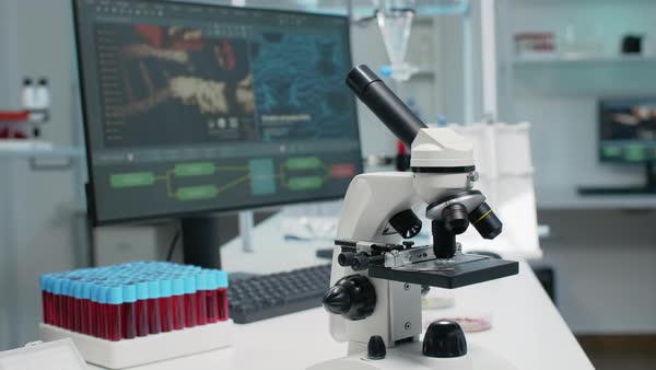 Close up of laboratory microscope on desk with medical research ...