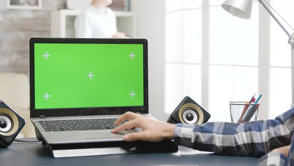 Man sitting at the desk in bright and well lit living room looking at ...