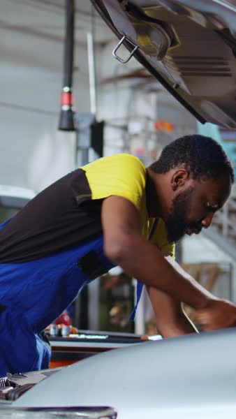 Vertical video Certified engineer in car service picks torque wrench ...