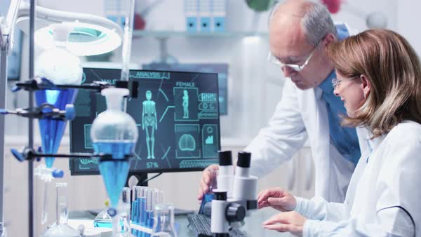 In modern research laboratory two researchers are talking about a ...